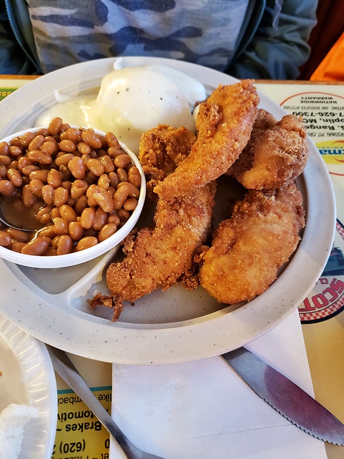 The holy trinity of heartland dining: perfectly fried chicken, hearty baked beans, and potato salad that tastes like someone's grandma made it with love.
