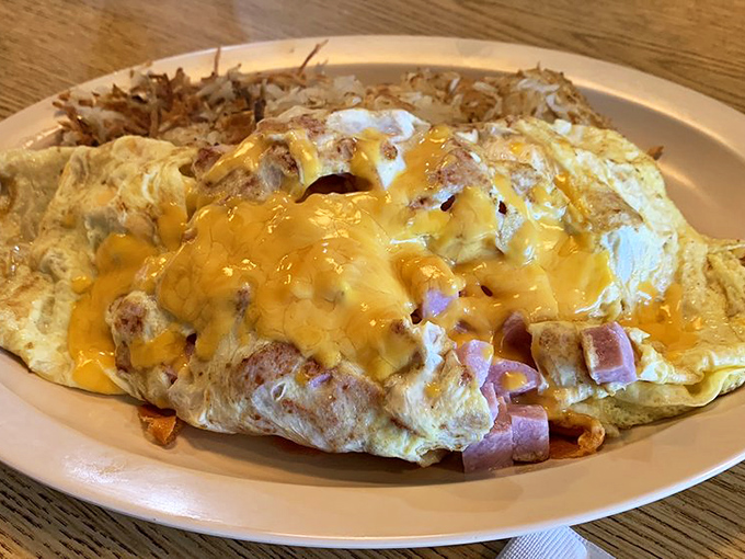 Behold the ham and cheese omelet in its natural habitat &ndash; a simple diner plate where melty goodness meets golden perfection.