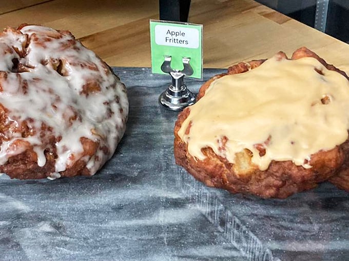 The holy trinity of donut perfection: a sign proclaiming "Apple Fritters," flanked by two specimens that make a compelling case for breakfast as art form.