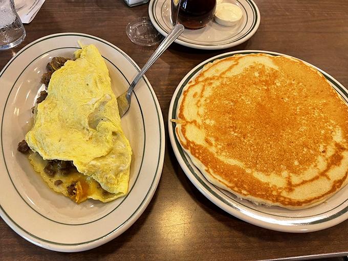The breakfast power couple&mdash;a hearty omelet and golden pancake sharing a table like old friends catching up over coffee.