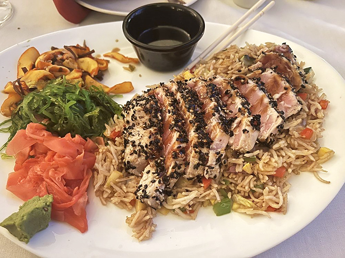 Sesame-crusted tuna sliced with surgical precision, resting on a bed of rice that's absorbed all the right flavors. Chopsticks or fork &ndash; your move.