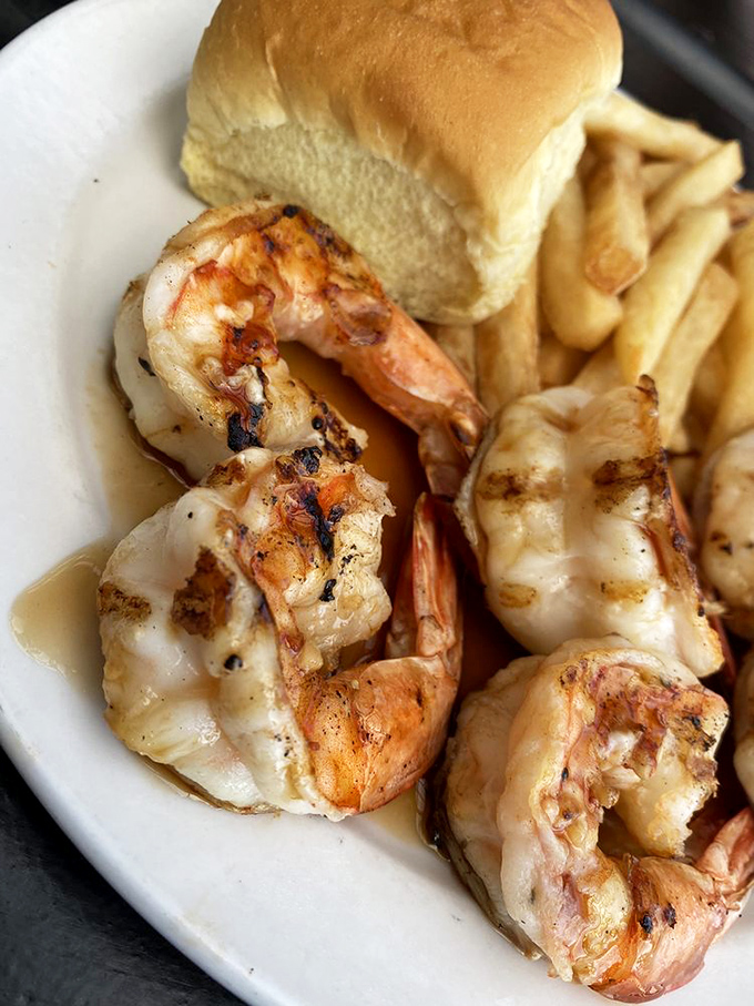 Grilled shrimp that have clearly been introduced to fire at exactly the right moment, lounging beside fries like they're on a seafood beach vacation.