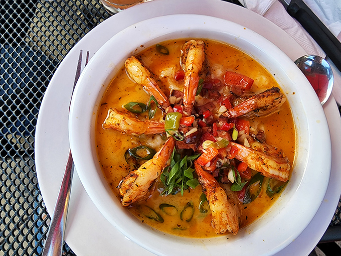 Each spoonful delivers a different note in this symphony of flavors. The shrimp are the soloists, but the grits are the orchestra.