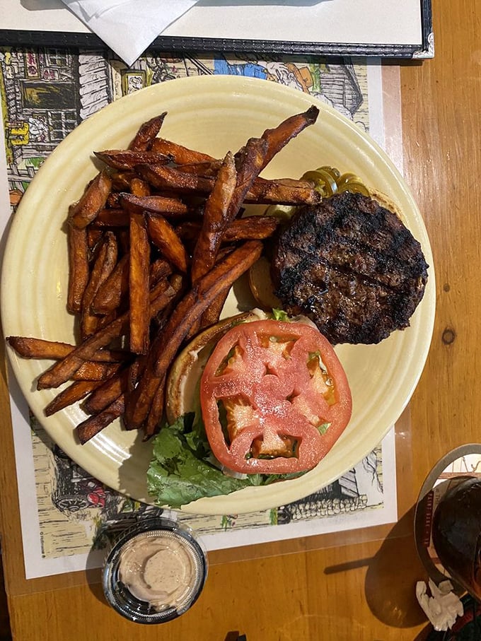 Sweet potato fries that actually taste like sweet potatoes! The burger's perfect char marks are basically a diploma from the University of Grilling.