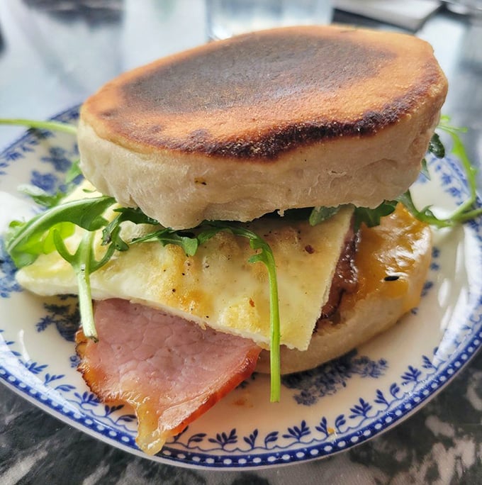 The anatomy of contentment: house-made English muffin, perfectly cooked egg, crisp bacon, and just enough greenery to pretend you're being virtuous.