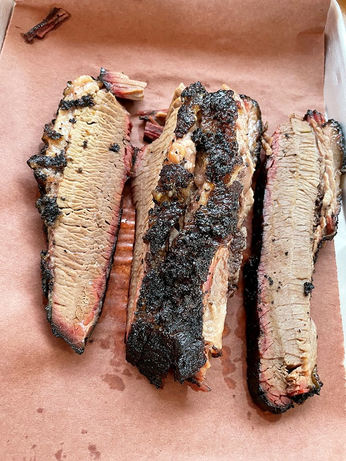 Brisket with a bark so perfect it belongs in a museum. That pink smoke ring isn't just for show&mdash;it's a halo of flavor earned through hours of patience.