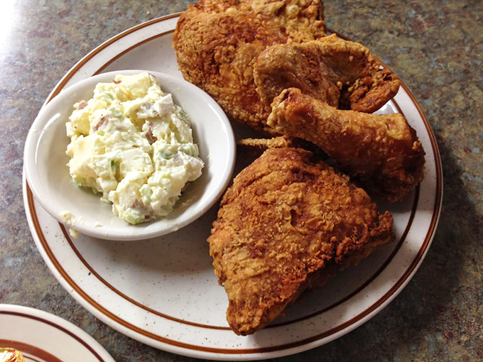 Broasted chicken so perfectly golden it belongs in a museum, paired with potato salad that makes you question all other potato salads you've ever known.