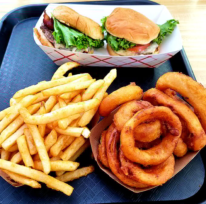 The ultimate comfort food trifecta—burgers, fries, and onion rings. This tray contains more joy than most people experience in an entire week.