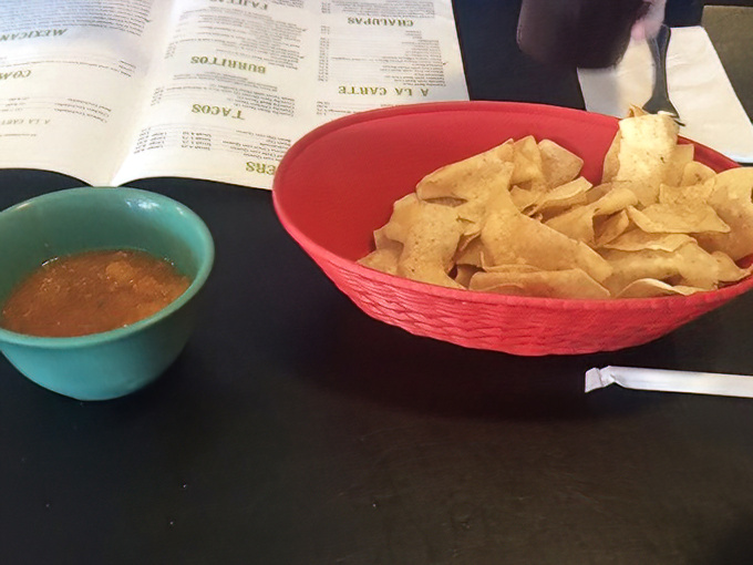 The chips arrive crisp and warm, like they just stepped out of the fryer and into your heart.