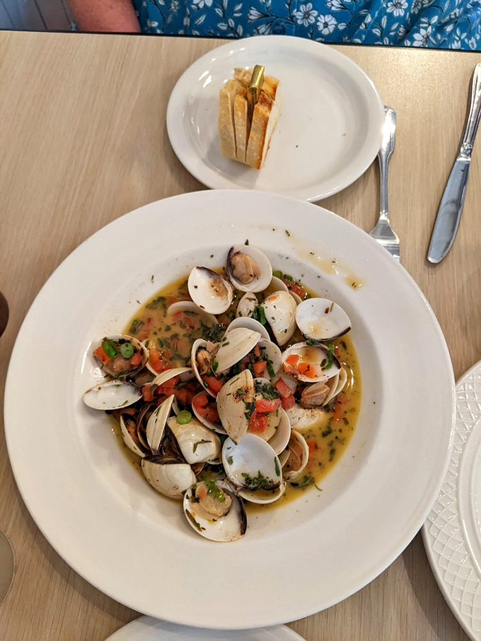 These Manila clams swimming in herb-infused broth are like tiny flavor bombs waiting to explode. The bread's just there to soak up the evidence.