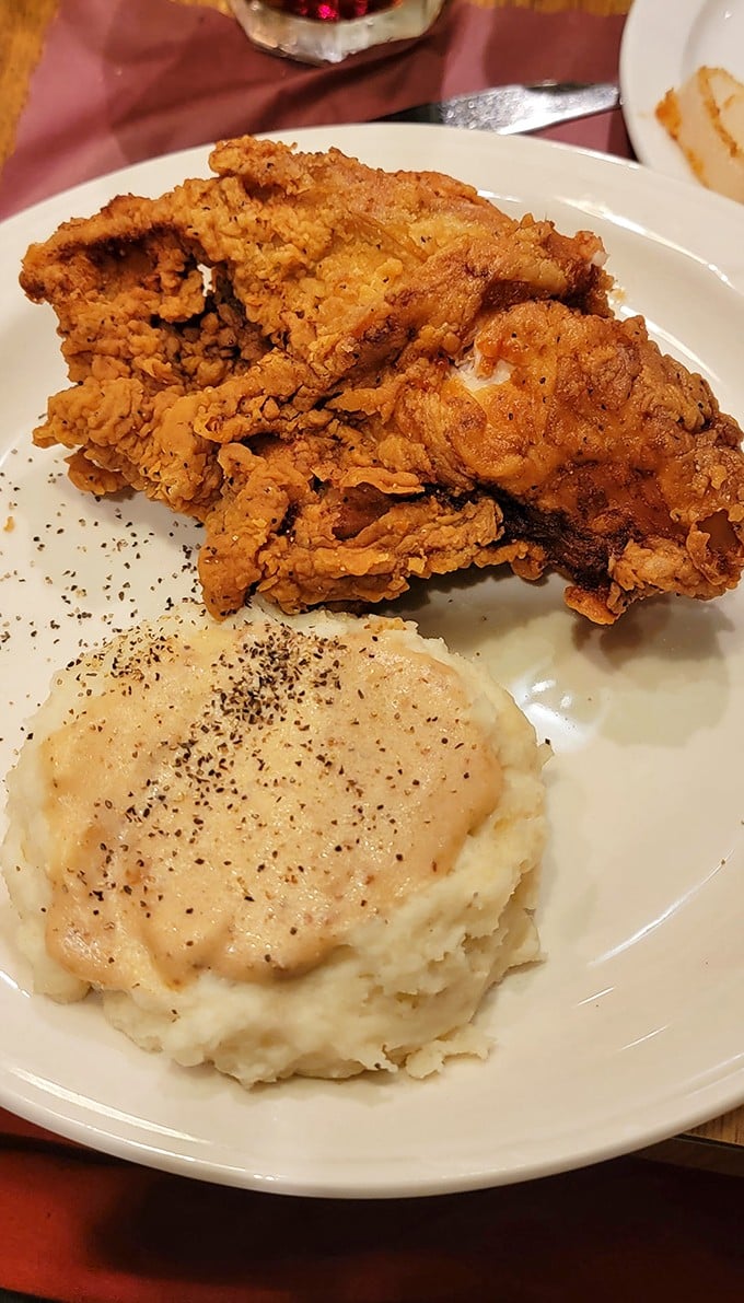 Country fried chicken with a crust that crackles like autumn leaves, nestled next to mashed potatoes drowning happily in gravy. Comfort food that hugs your insides.