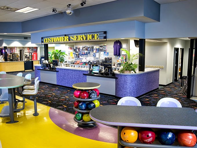 The customer service counter, with its distinctive purple facade, serves as mission control for an evening of bowling bliss.