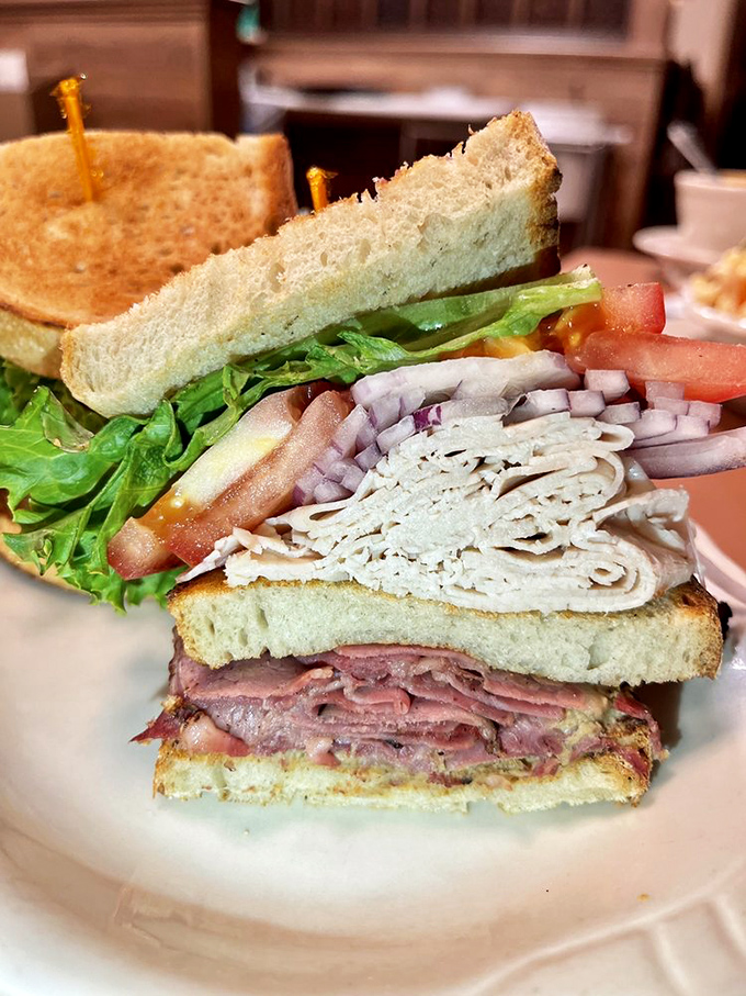 This triple-decker club sandwich contains more layers than a Christopher Nolan movie, and infinitely more satisfying to navigate.