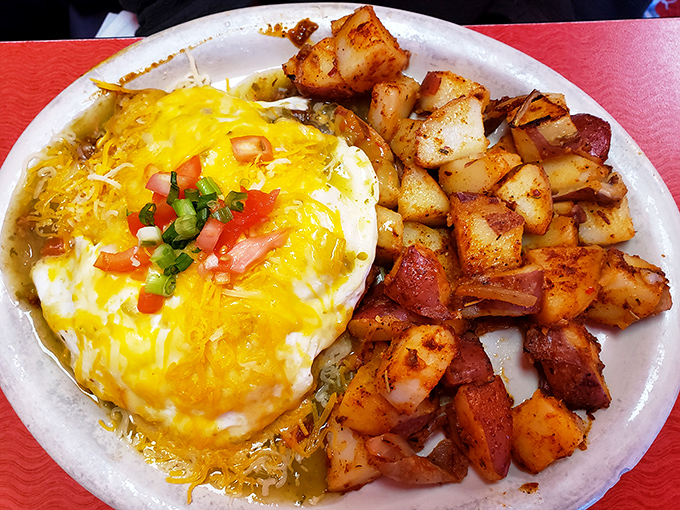 Those home fries look like they got PhDs in crispiness, while the eggs huddle under a blanket of melted cheese and fresh pico.