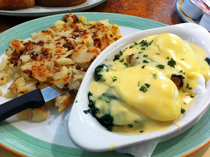 Eggs Benedict gets the Florentine treatment here, with hollandaise sauce cascading like a yellow waterfall over perfectly poached eggs and vibrant spinach.