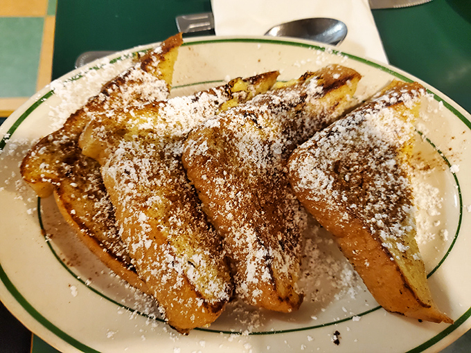 French toast that's achieved the impossible: crispy edges, custardy centers, and enough powdered sugar to make your dentist wince with delight.