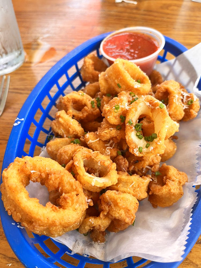 Golden-fried calamari rings that crunch like nature's perfect snack food, with marinara sauce playing the supporting role it was born for.