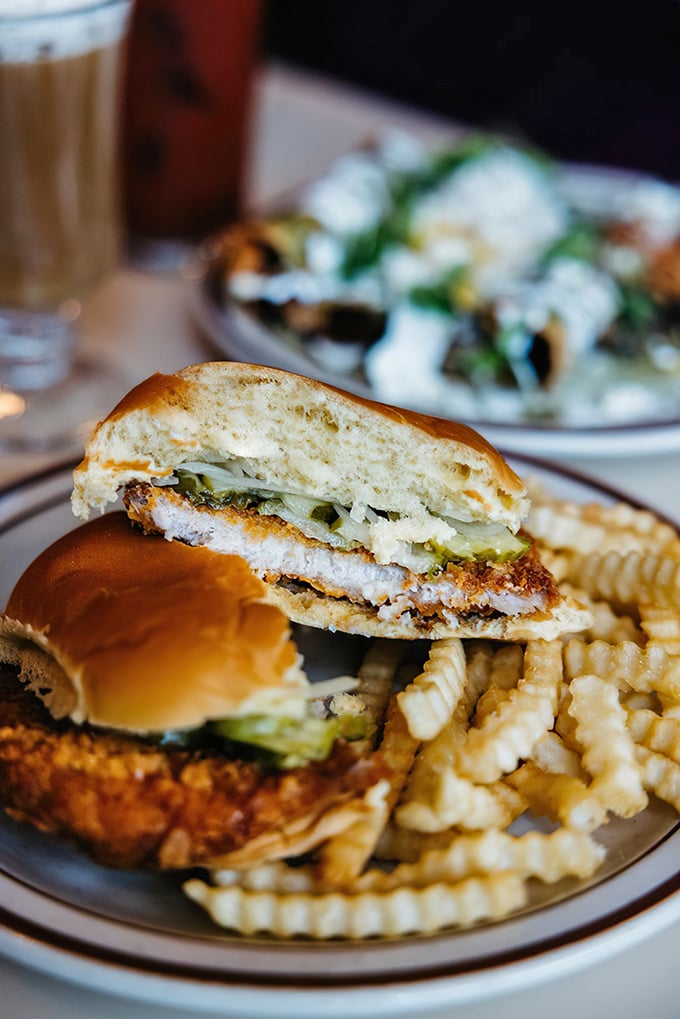 Not just a sandwich but an architectural marvel—crispy breaded tenderloin, fresh toppings, and crinkle-cut fries that deserve their own fan club.