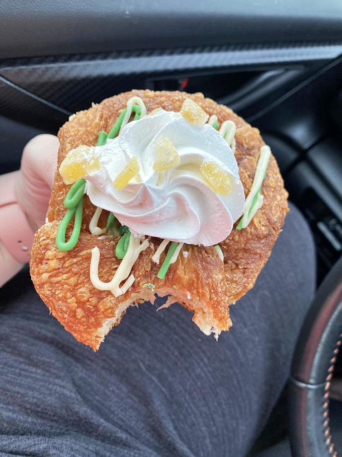 This cronut creation looks like it escaped from a pastry fever dream. Green drizzle, cream swirl, and crystallized ginger create edible art.