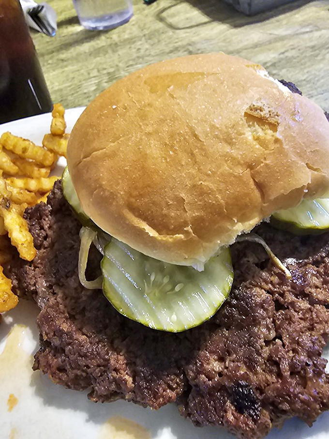 When your burger requires its own zip code, you know you're in for something special. The bun struggles valiantly with its meaty mission.