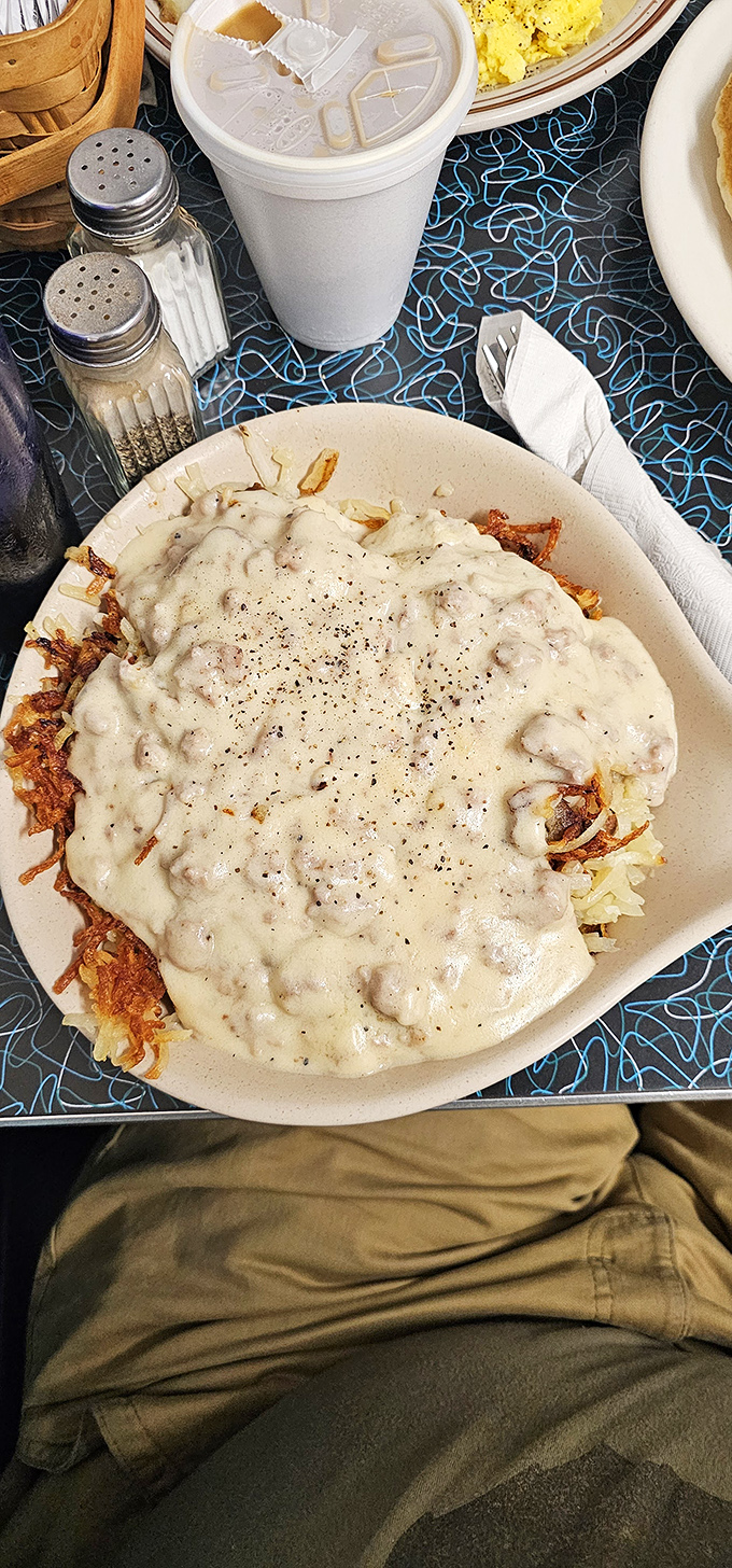 Comfort on a plate: golden hash browns baptized in creamy sausage gravy. The kind of breakfast that makes you forgive Monday for existing.