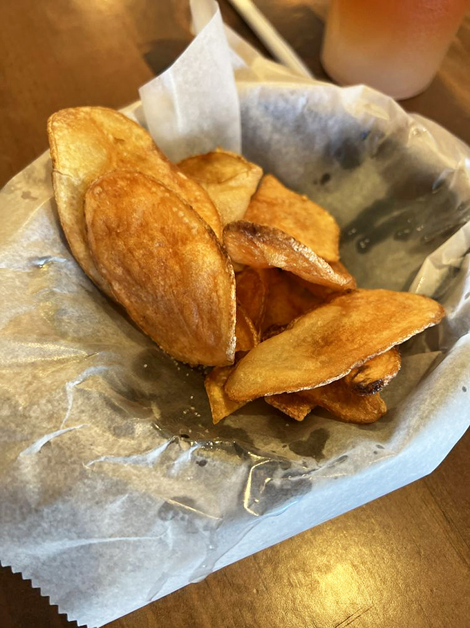 These homemade chips aren't just fried potatoes; they're golden discs of crunch that whisper "one more" until the basket mysteriously empties.