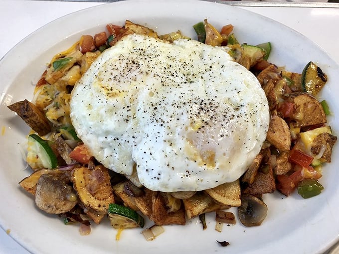 Vegetables hiding under a perfectly fried egg pretending they're the star of the show. Nice try, veggies, but we see through your delicious ruse. 