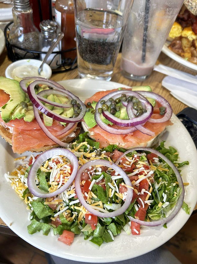 Not just a bagel sandwich, but a complete narrative of flavor with luxurious lox, crisp veggies, and a side salad for those pretending to be healthy.