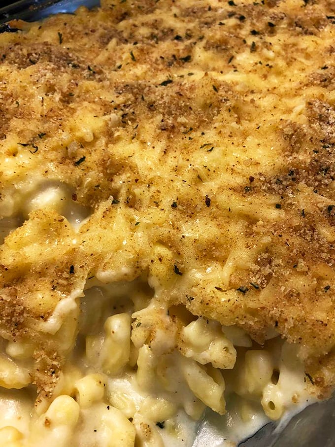 Mac and cheese with a golden crust that crackles like autumn leaves, hiding a creamy treasure underneath that would make any childhood memory jealous.