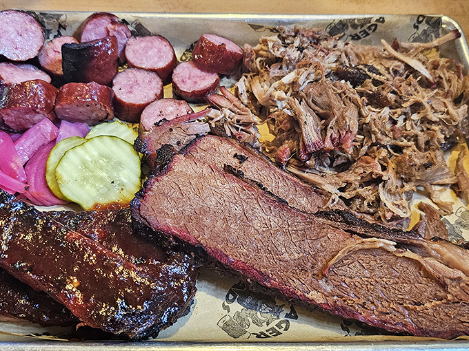 The carnivore's dream team: brisket with that telltale smoke ring, pulled pork, and sausage sharing a tray like old friends at a reunion.
