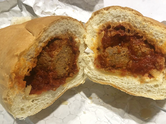 The meatball sub, cut in half to reveal its soul&mdash;tender homemade meatballs swimming in marinara that's been perfected over generations.