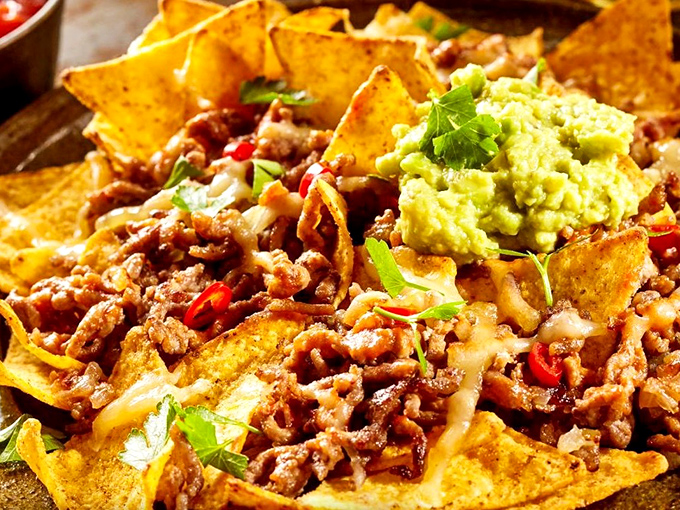 Nachos that laugh in the face of portion control, where every chip is a vehicle for maximum flavor delivery and guacamole adds that perfect creamy counterpoint.