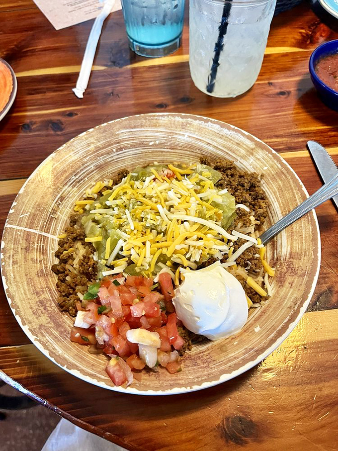 The naked burrito bowl strips away the tortilla but keeps all the glory – a colorful landscape of flavors topped with that signature dollop of sour cream.