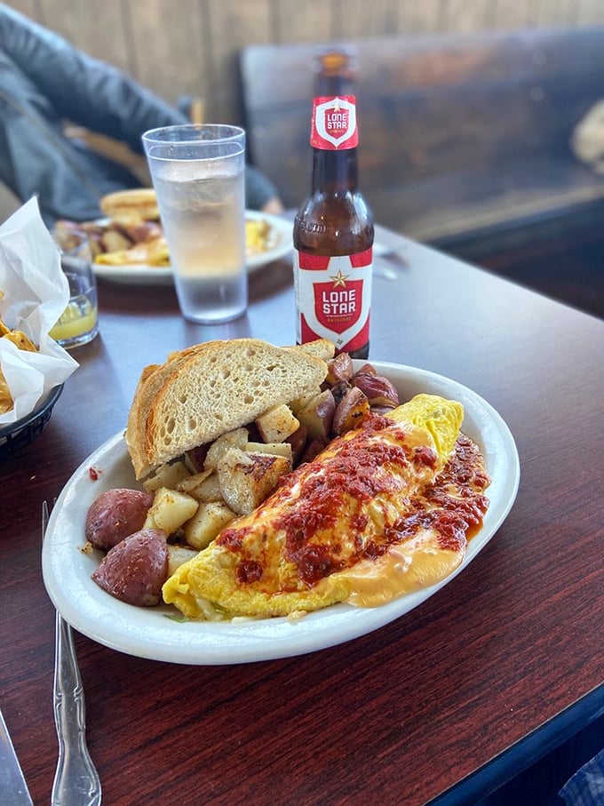 When an omelet meets Texas hospitality &ndash; generously stuffed, perfectly folded, and served with a Lone Star beer because sometimes breakfast deserves a sidekick.