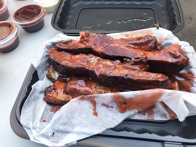 Pork ribs nestled in butcher paper like precious cargo. The spice-crusted exterior hints at the flavor journey that awaits.
