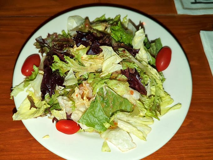 Even the salad looks happy to be here, a fresh counterpoint to all that glorious meat and cheese.