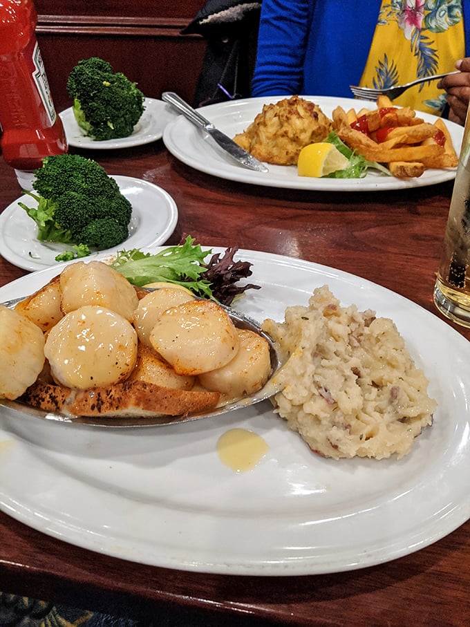 Scallops so perfectly seared they deserve their own Instagram account, nestled beside creamy mashed potatoes like ocean treasures on a sandy shore.