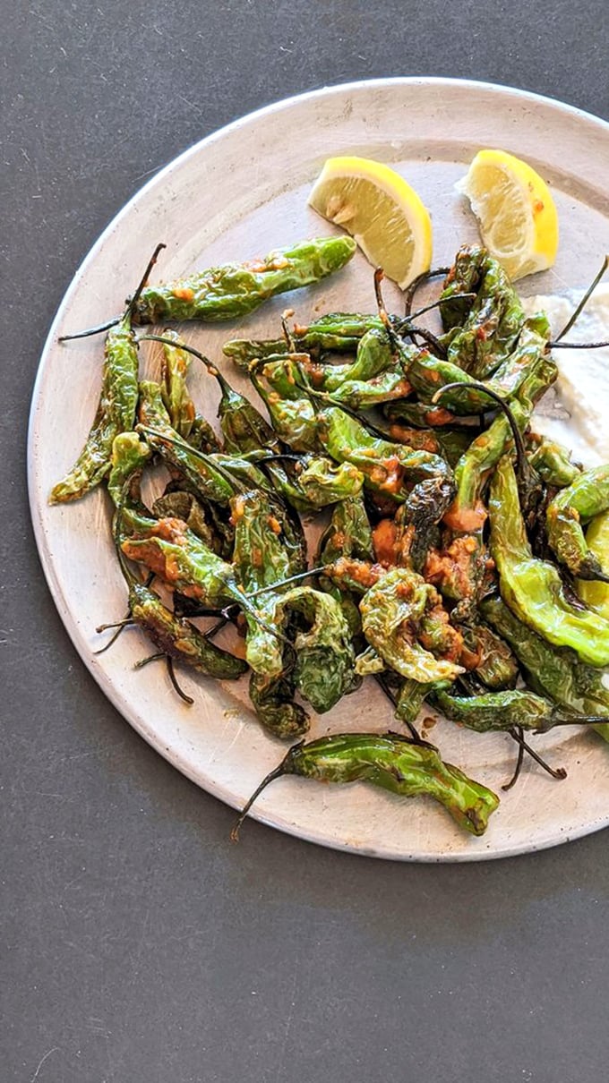 Blistered shishito peppers provide a welcome vegetal interlude between burger bites. Consider them the palate-cleansing green space in your meat metropolis.