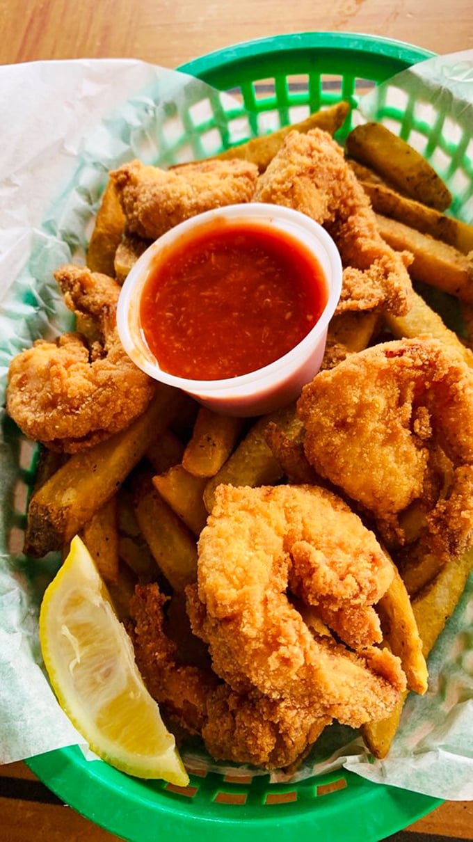 Golden-fried shrimp nestled against crispy fries with a lemon wedge standing by. Seafood comfort food at its most honest.