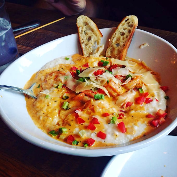 Red peppers add pops of color to creamy grits like confetti at a flavor parade. This dish makes you understand why people plan road trips around restaurant visits.