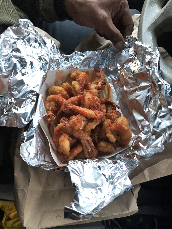 When the sauce meets those perfectly fried shrimp, it's like a culinary romance novel unfolding right there in your aluminum foil container.