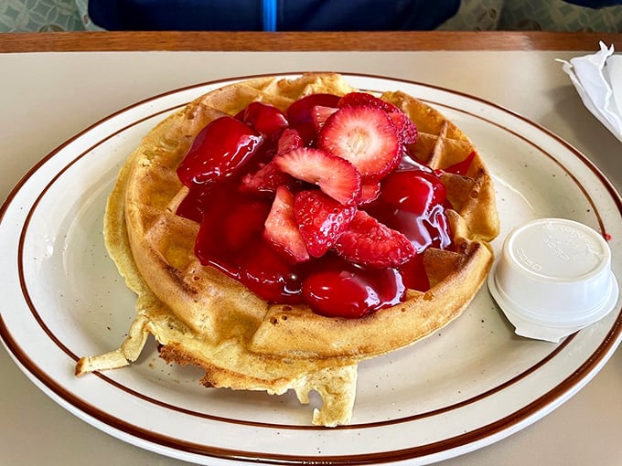 That waffle isn't just topped with strawberries; it's wearing them like jewelry to the breakfast ball. Berry-licious formal attire.