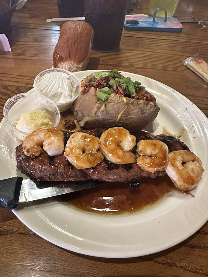 Land meets sea in perfect harmony&mdash;grilled steak topped with succulent shrimp alongside a loaded baked potato that's dressed better than I am most days.