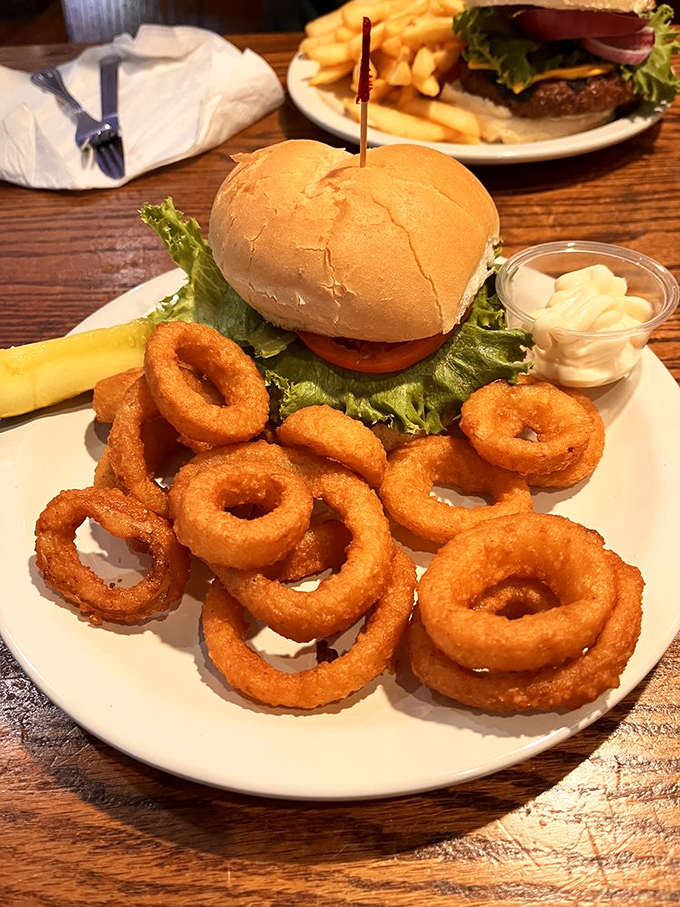 This isn't just a burger; it's a work of art surrounded by golden onion rings that crunch so perfectly you'll hear them in your dreams.