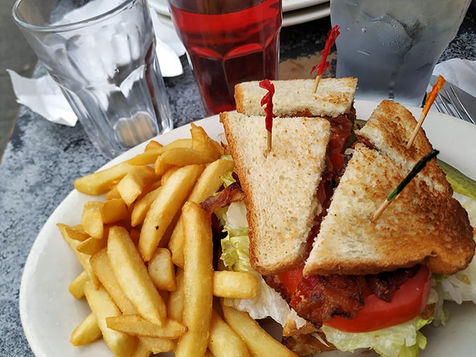 The classic club sandwich, stacked tall enough to require jaw gymnastics, with crisp fries standing by for the inevitable moment when half falls onto your plate.