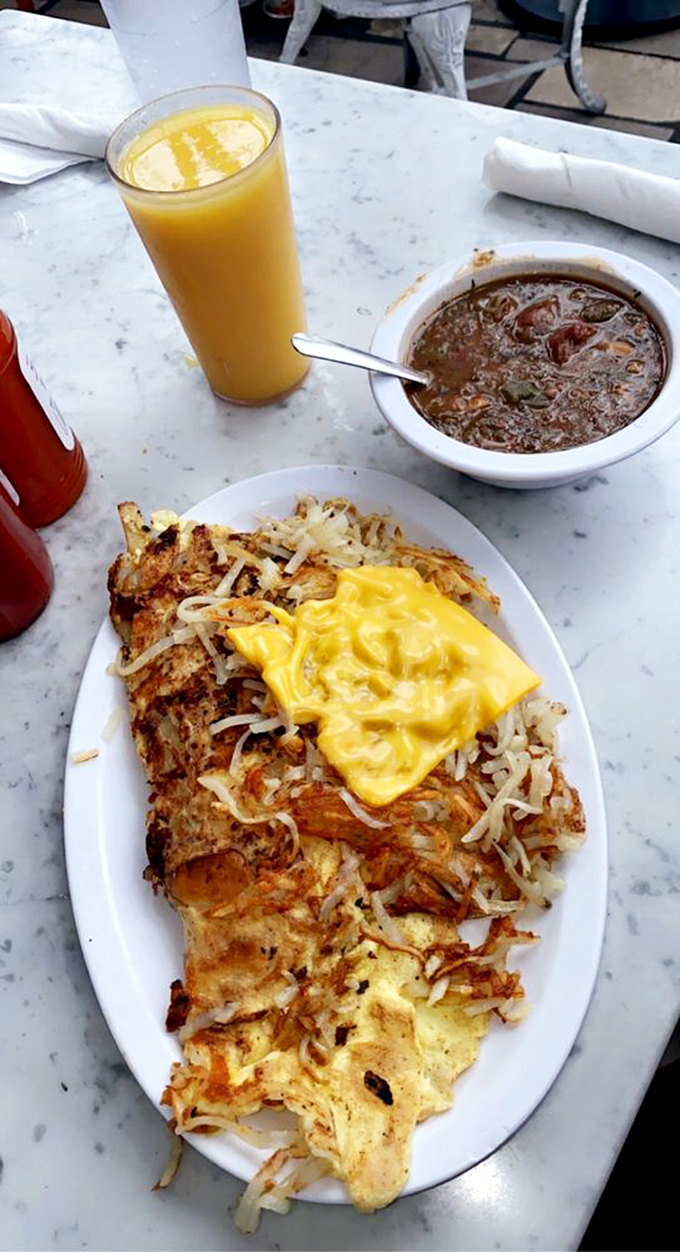 Not just an omelet but a golden canvas of eggs cradling a masterpiece of fillings, with hash browns that crackle with each bite.