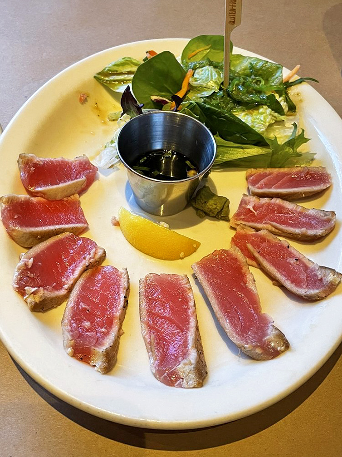 Rare ahi tuna, seared just enough to say hello to heat, arranged like ruby jewels with a side of greens and soy sauce.