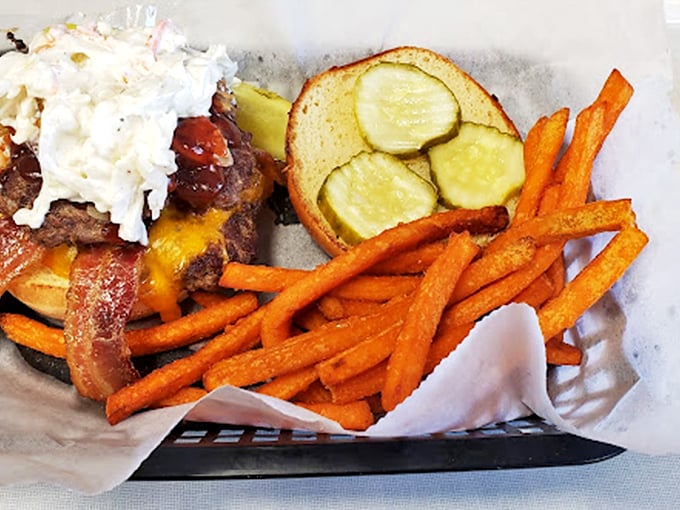 This isn't just a burger&mdash;it's an architectural marvel of beef, bacon, cheese, and fresh toppings, with sweet potato fries standing guard like delicious sentinels.