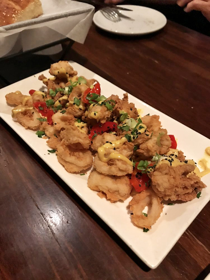 Crispy calamari that doesn't require a marathon chewing session is culinary gold. These golden-fried treasures with bright peppers might just convert seafood skeptics.