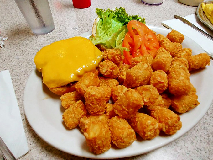 Comfort food royalty: golden tater tots surrounding a cheeseburger that doesn't need fancy aioli to prove its worth.